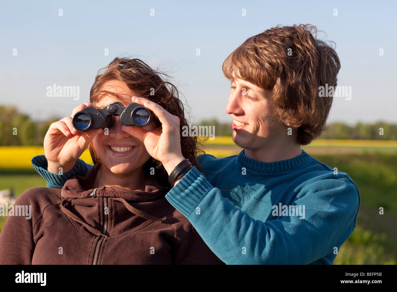 Couple using binoculars Stock Photo - Alamy