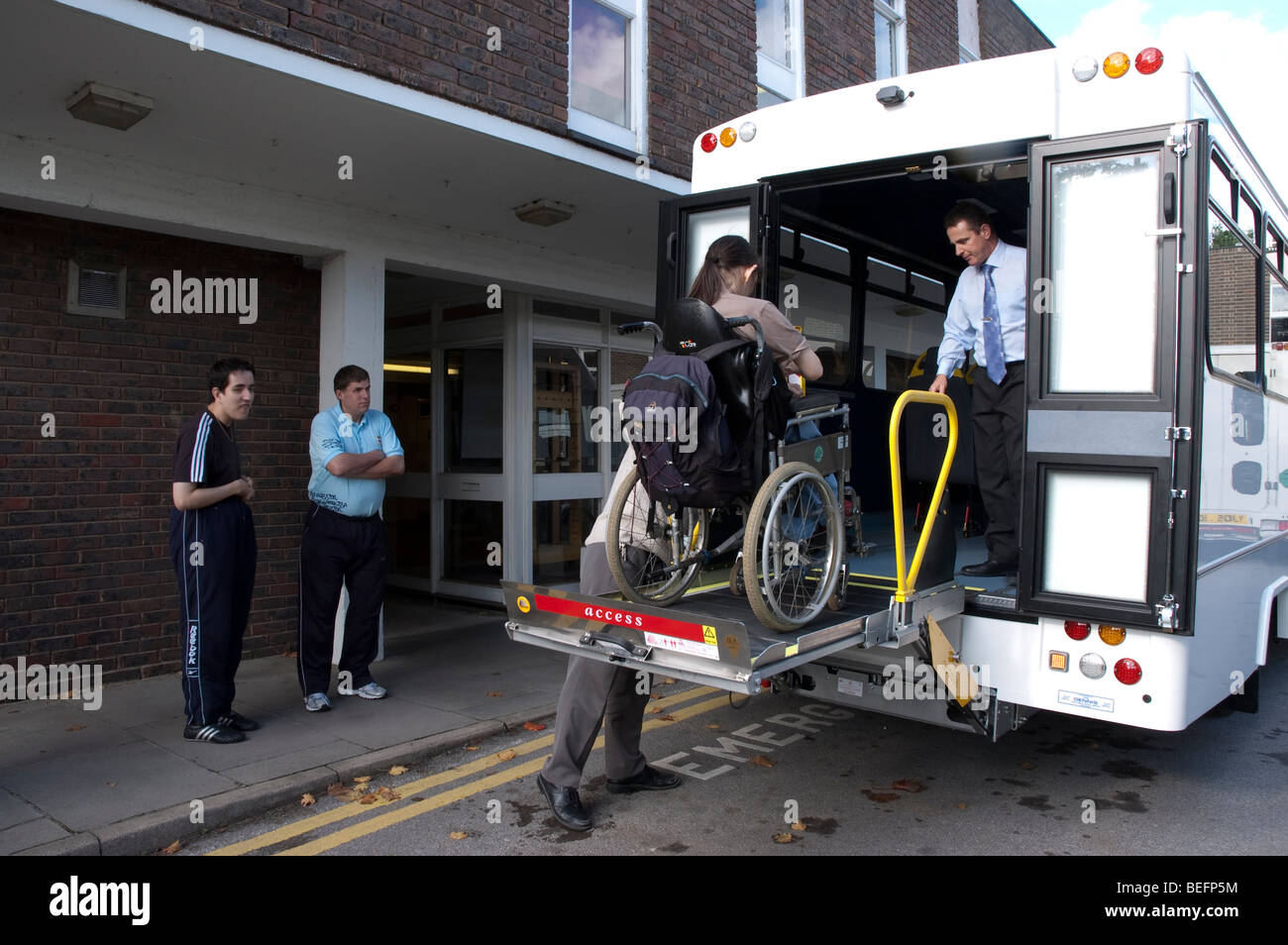 Loading a disabled person in a wheelchair into the rear entrance of a ...