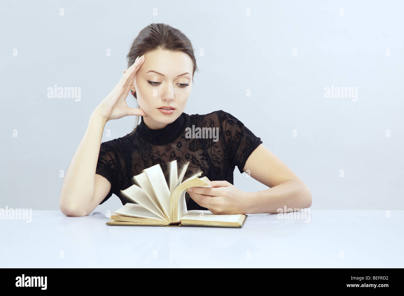 Attractive lady reading the book indoors Stock Photo - Alamy
