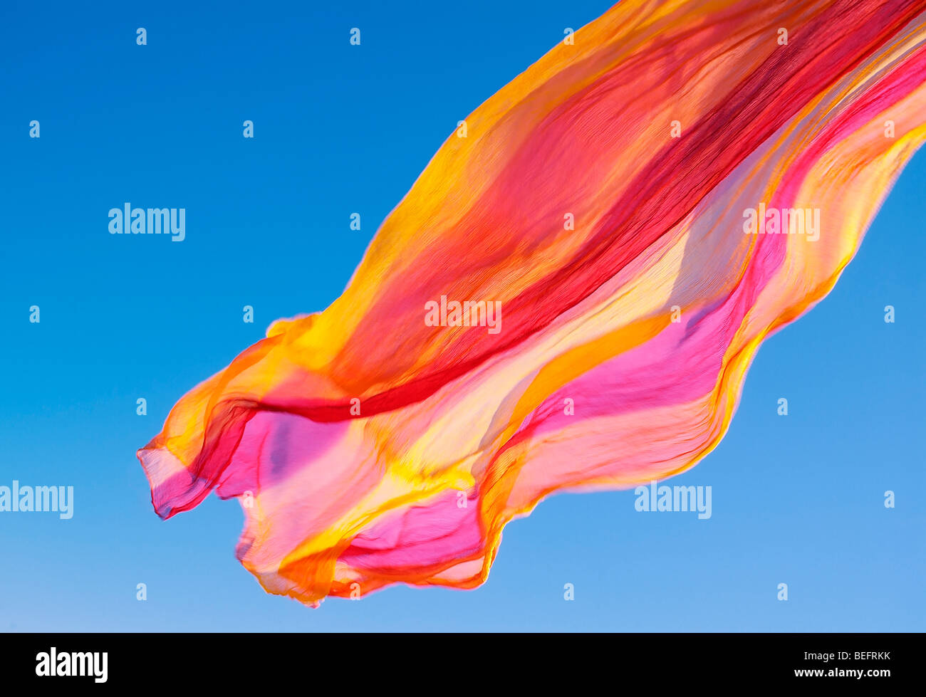 Multicolor cloth flying against blue sky Stock Photo - Alamy