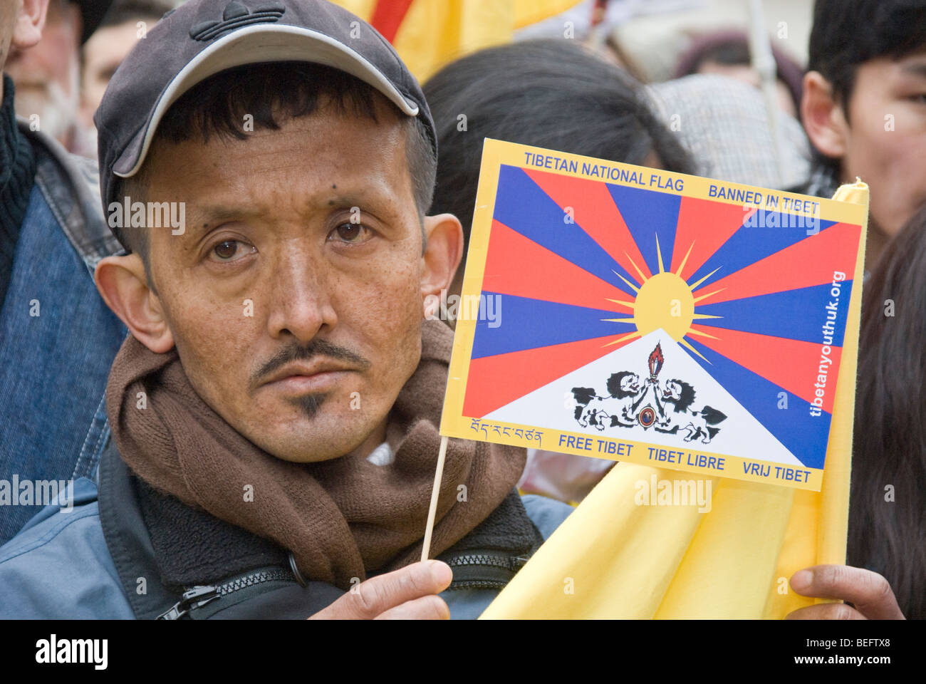 Tibetan man hold Free Tibet flags at a packed rally in London with the ...