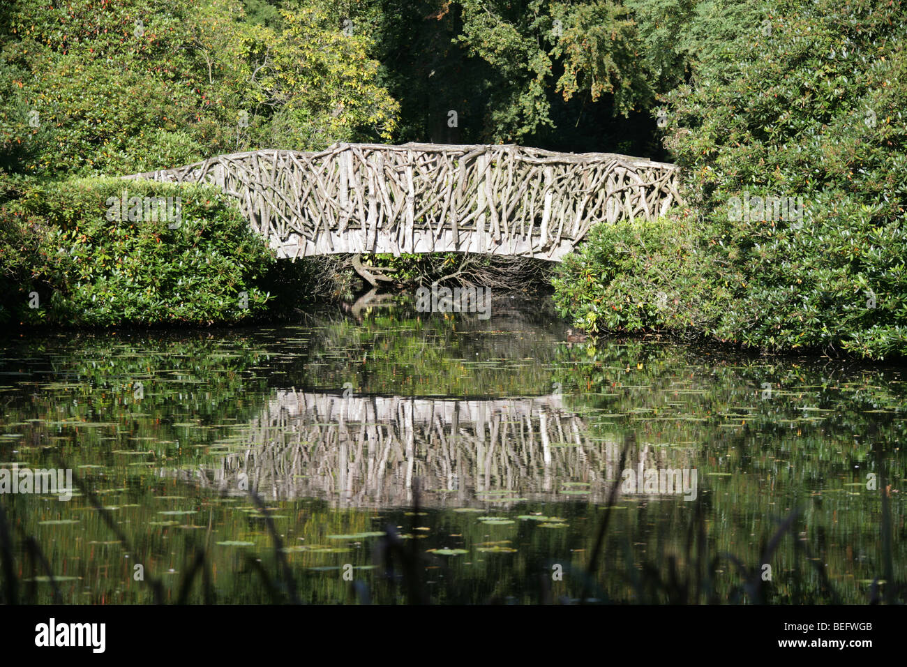 Estate of Tatton Park, England. Wooden wicker style bridge reflected in ...