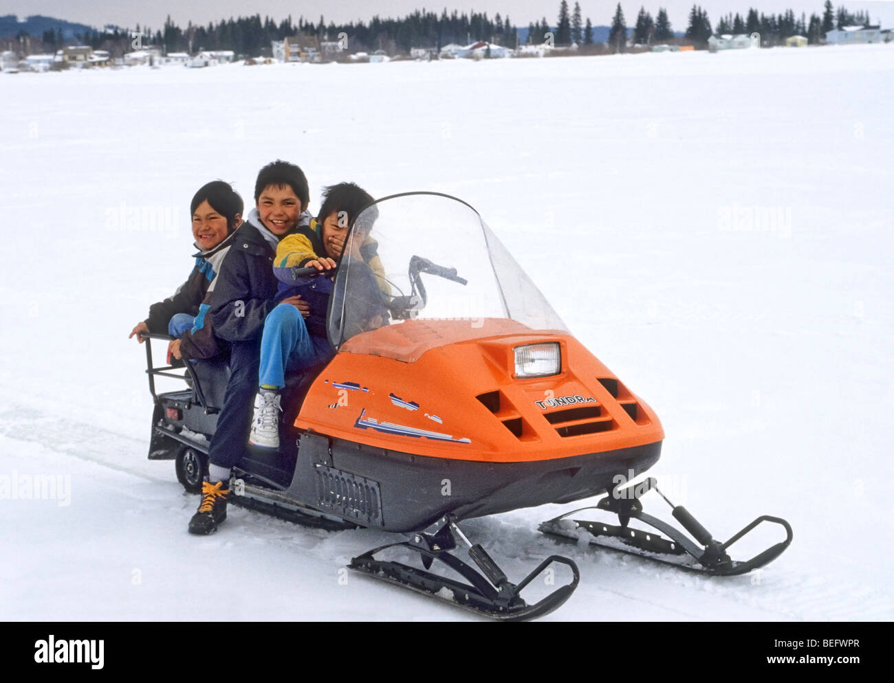 Innu (Native) children ride snowmobile to play during winter in village ...