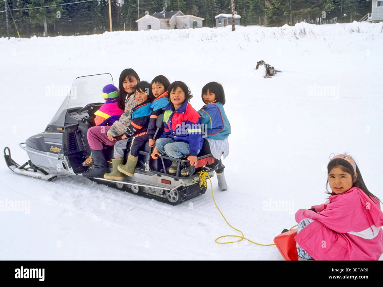 Innu (Native) children pile onto snowmobiles to play during winter in ...