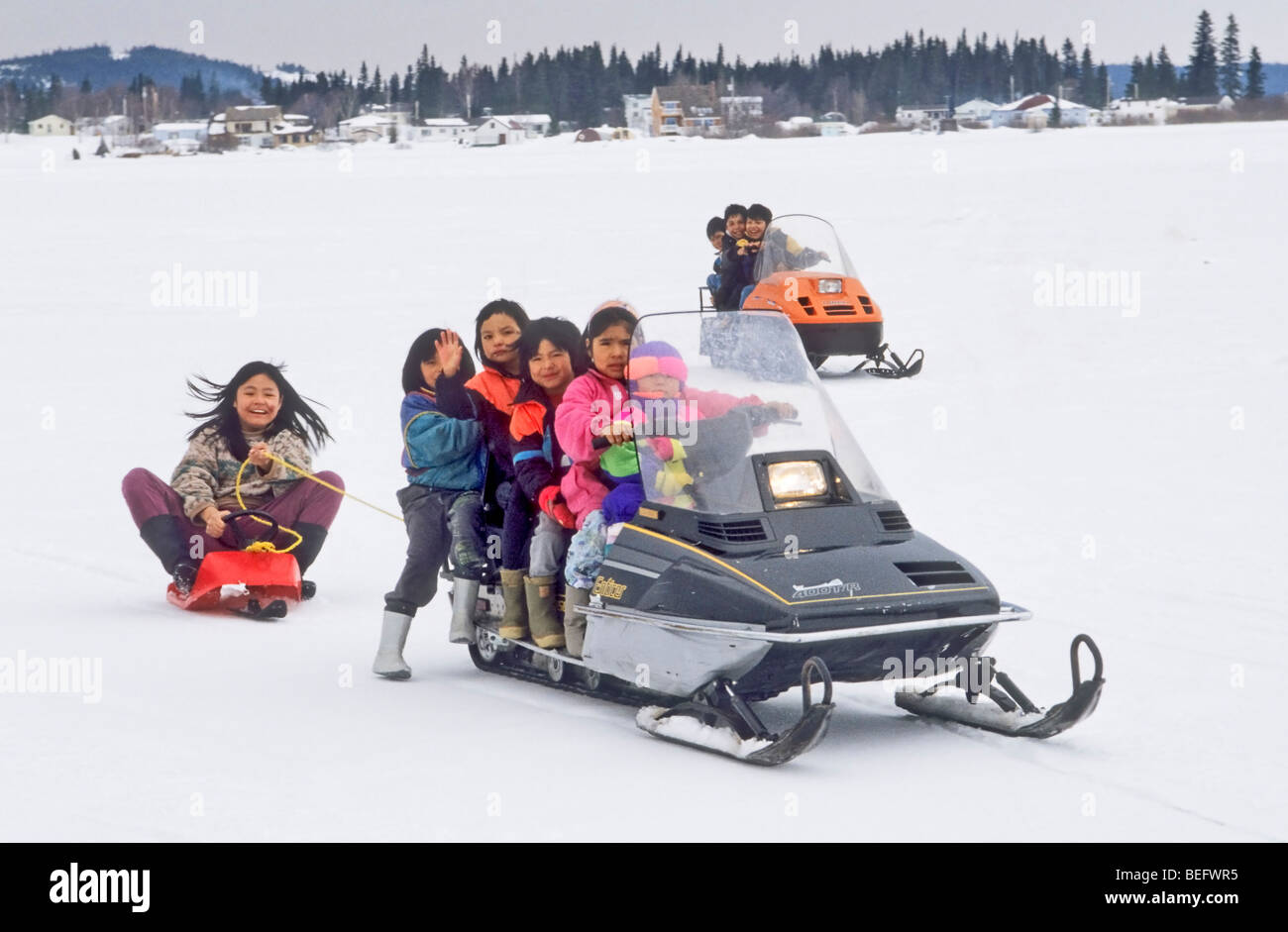 Innu (Native) children pile onto snowmobiles to play during winter in ...