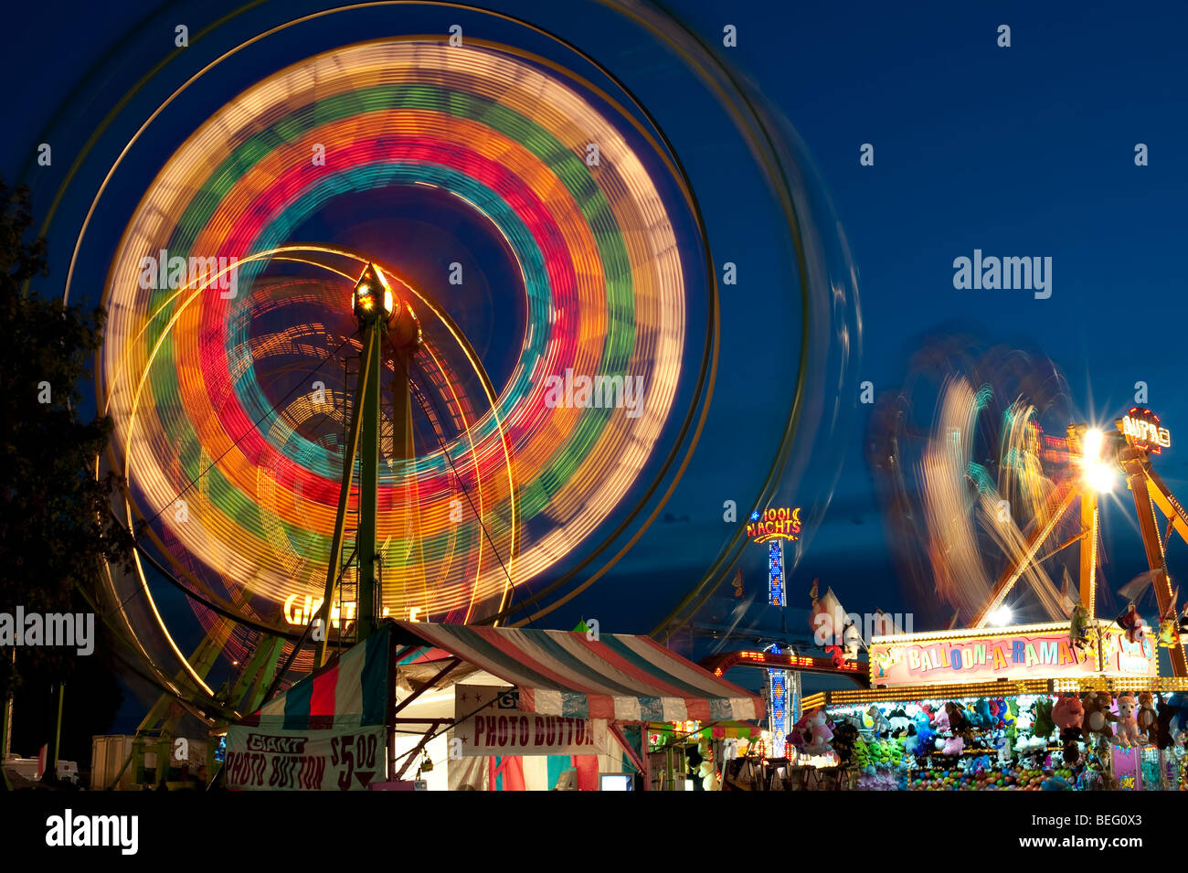 Evergreen State Fair at twilight with Ferris Wheel and amusement rides ...