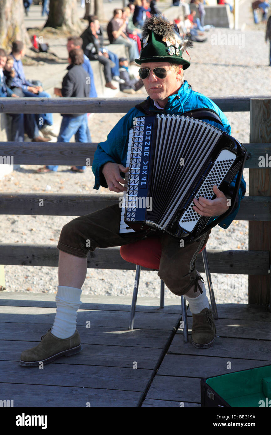 Bavarian accordion player at the Pier of Lake Ammersee in the city of ...