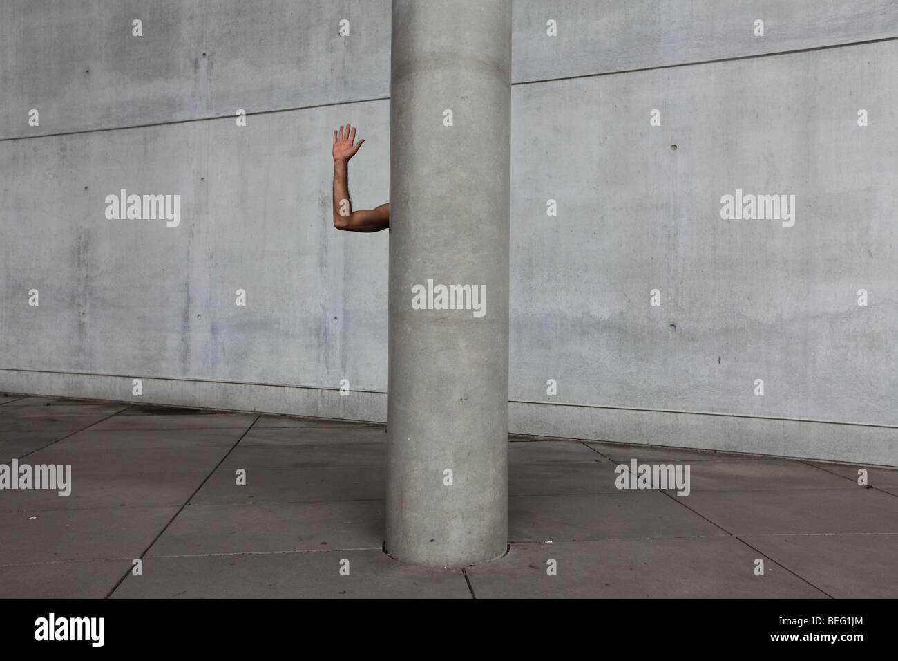 Person hiding behind Pillar Revealing Arm Stock Photo - Alamy