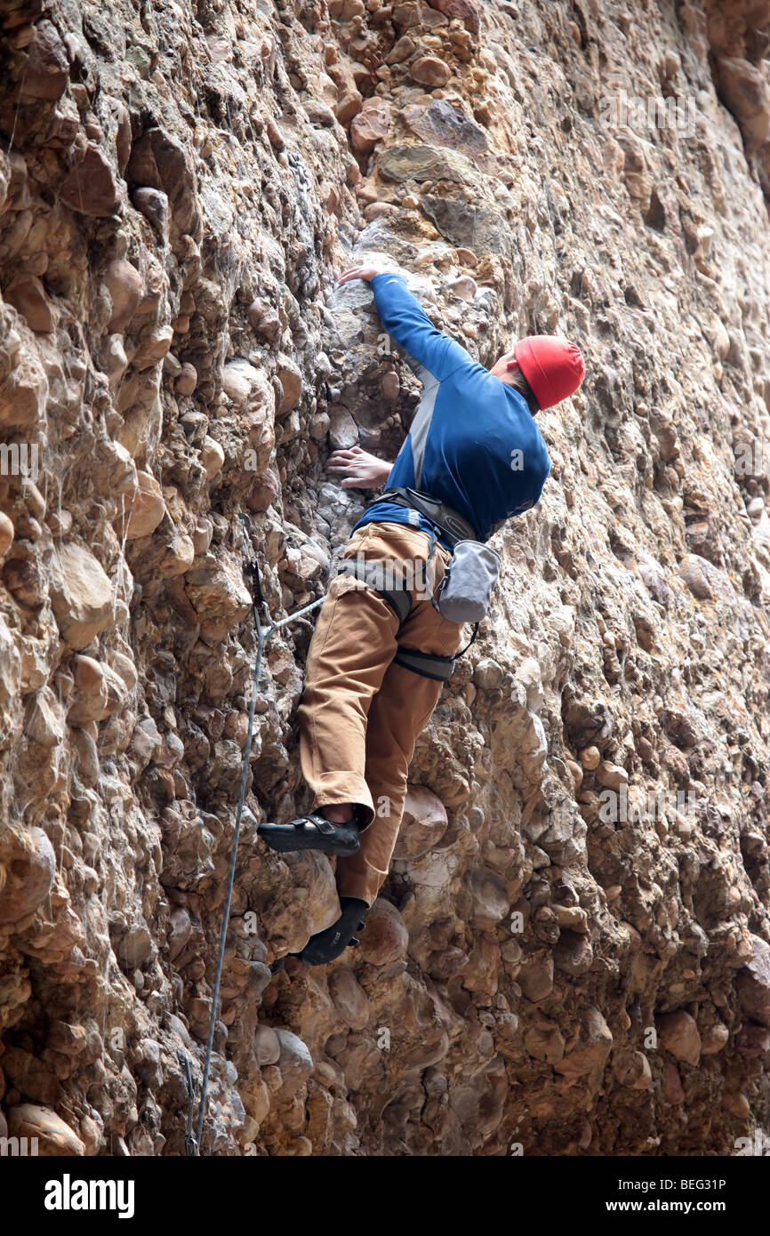 Rock climber ropes on a high rock ledge in central Utah. Steep climb ...