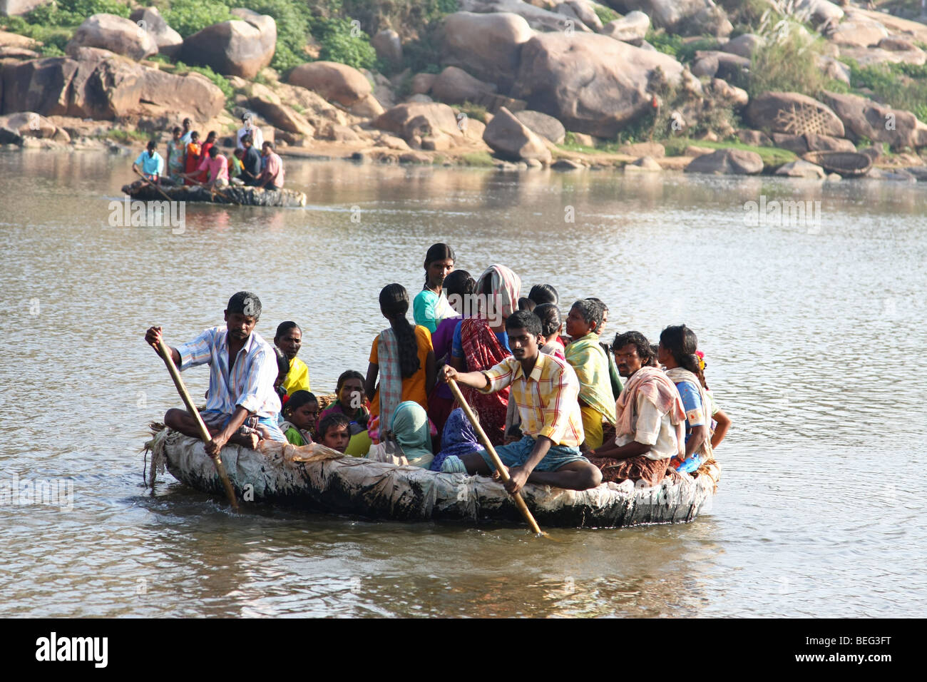 Crowded old-style rowboat crossing river Stock Photo - Alamy