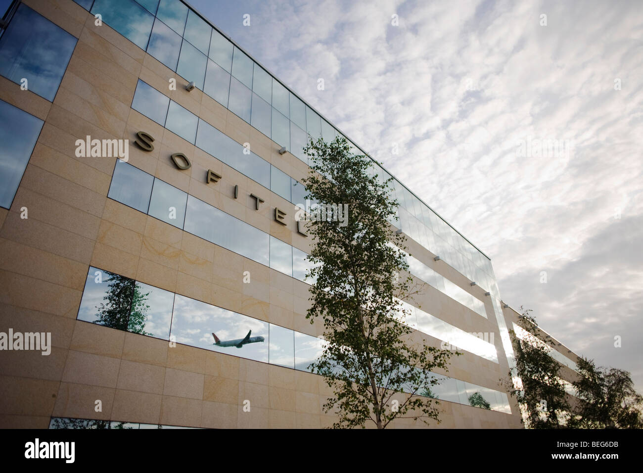Reflected in the windows of hotel chain Sofitel, a climbing aircraft ...