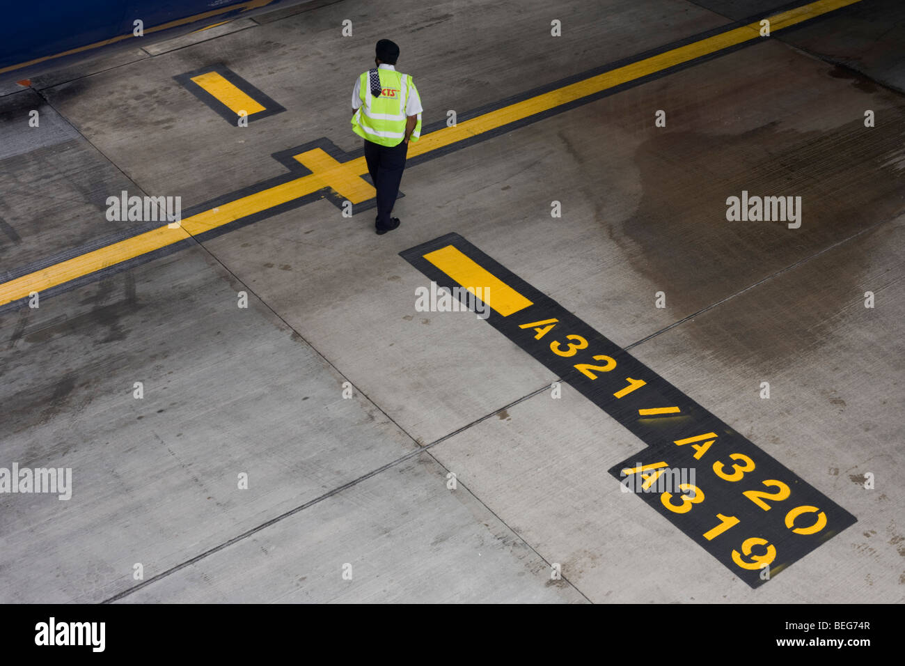 A British Airways security guard patrols beneath fuselage of a Boeing ...