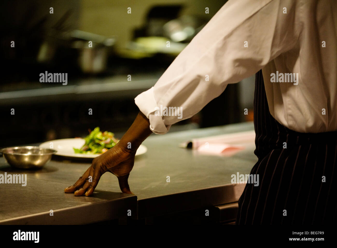A chef rests his hand in a food preparation area in kitchens at the ...