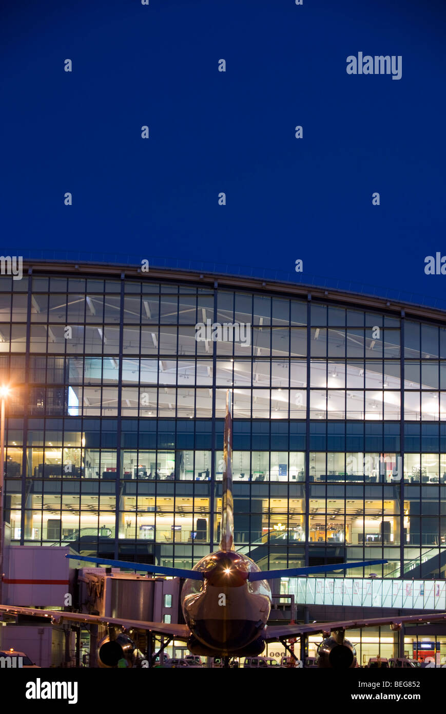 An exterior dusk view of a British Airways airliner parked at a gate at ...