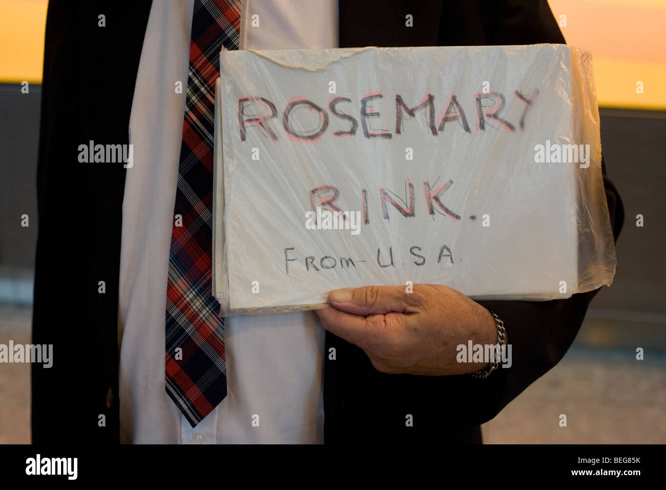 Greeting driver holding passenger lady's name card in Arrivals at ...