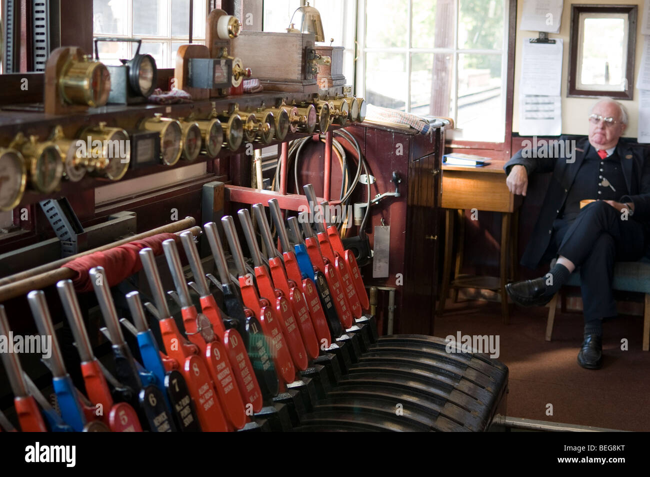 An old railway signal box with levers, clocks and signalman at ...