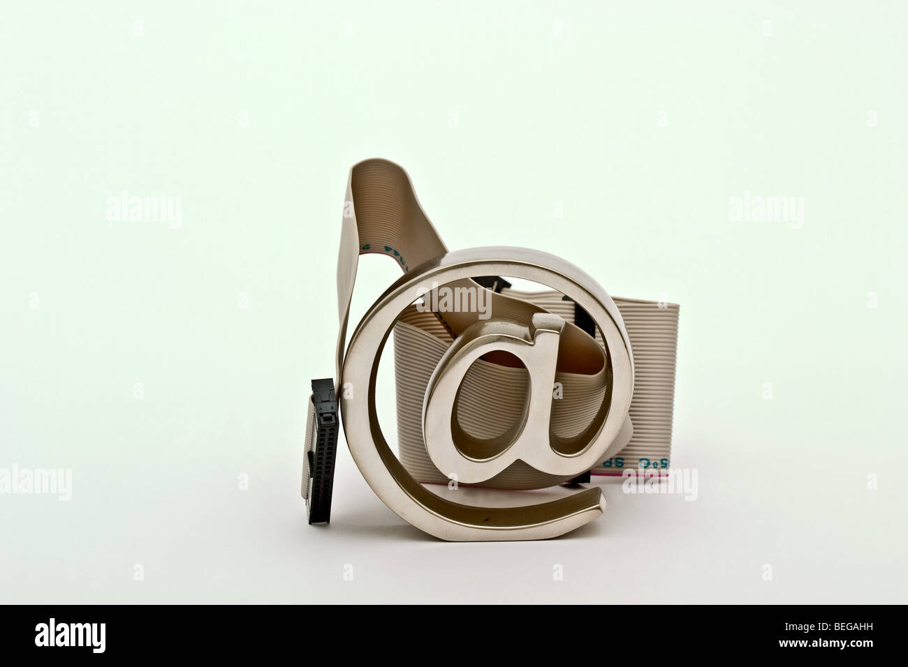 Metallic e-mail symbol in front of a ribbon connector Stock Photo - Alamy