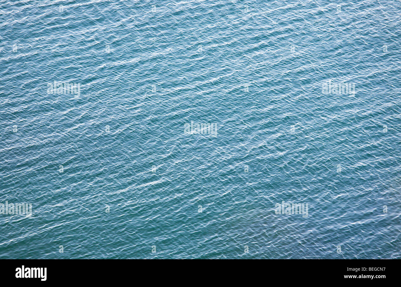 transparent coastal azure water surface with some stones on bottom ...