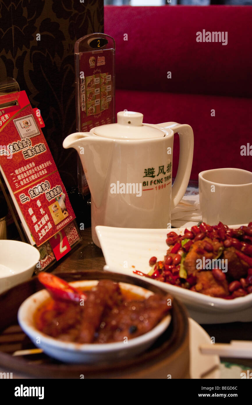 Table filled with food and a tea pot in a dim sum restaurant in ...