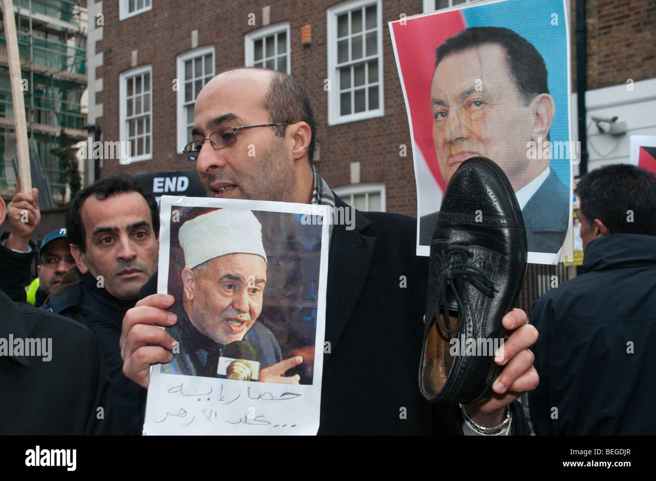Man with shoe and posters at protest at Egyptian Embassy calling for ...