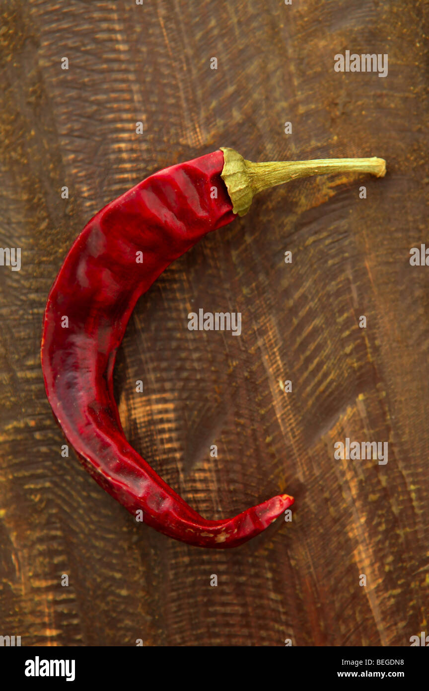 Red dried hot chili pepper over a dark wood background Stock Photo - Alamy
