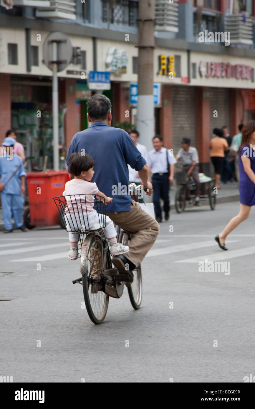 Man and child on a bike in Shanghai China Stock Photo - Alamy