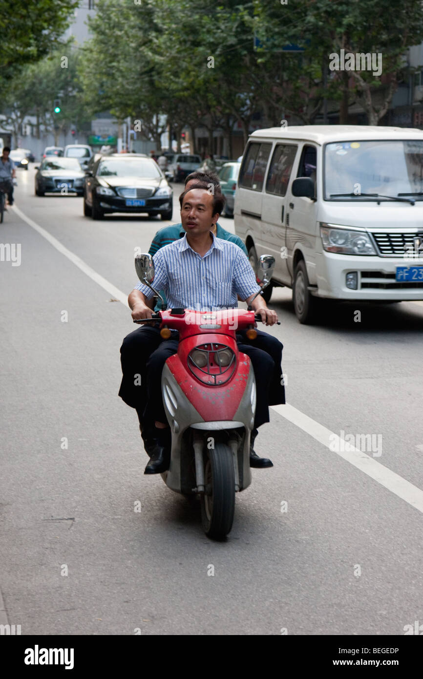 Two men on a moped in Shanghai China Stock Photo - Alamy