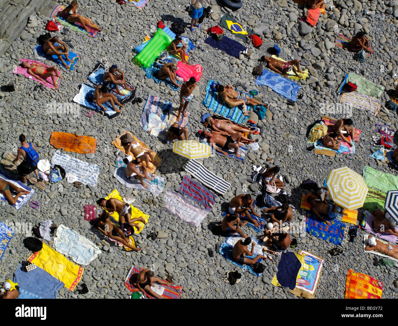 Sunbathers on the beach at Riomaggiore in the Cinque Terre region of ...