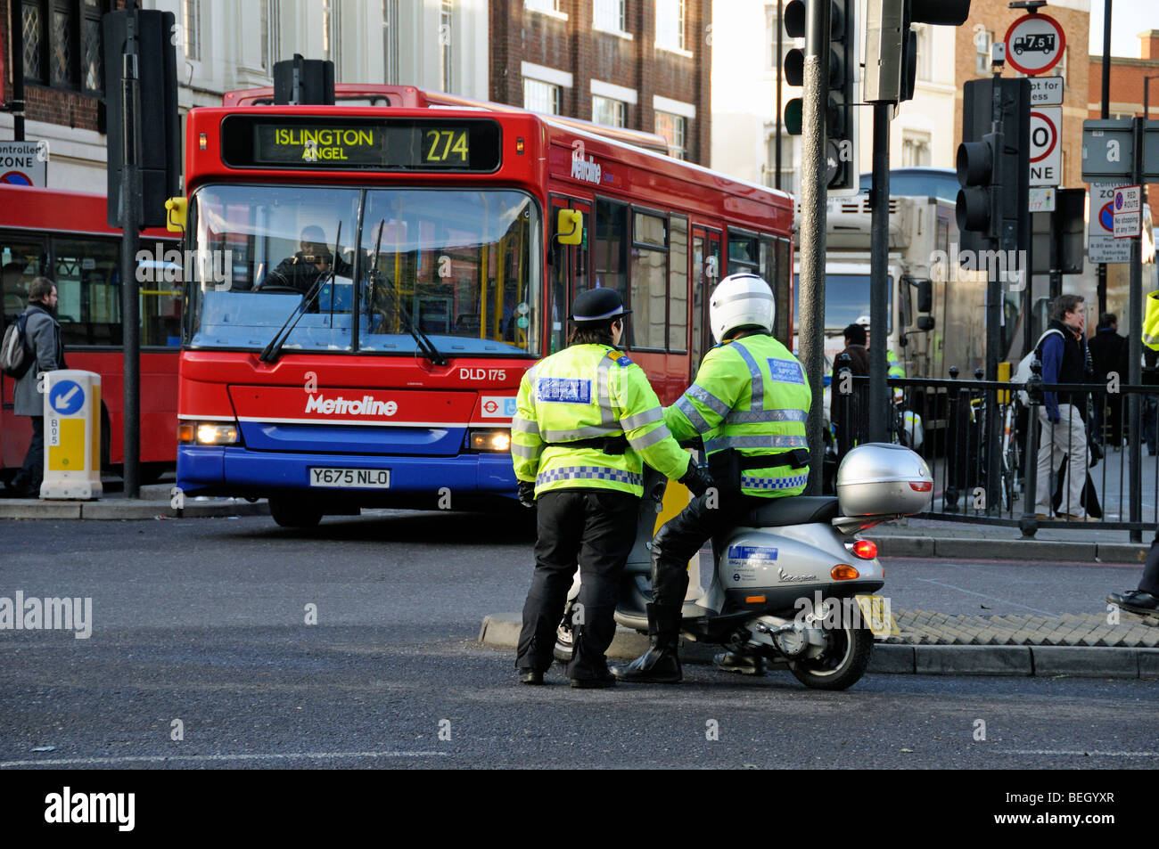 Police Community Support Officers, one on a scooter with a London bus ...