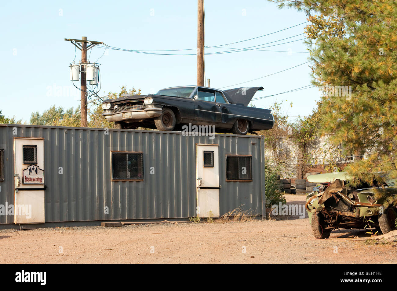 A wrecked car on the roof of a building. Recycling salvage junk office ...