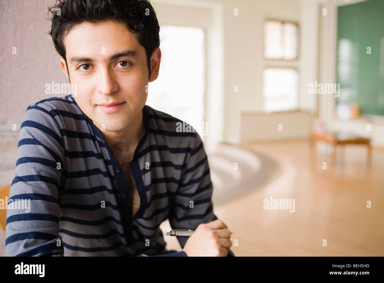 Portrait of a young man holding a pen Stock Photo - Alamy