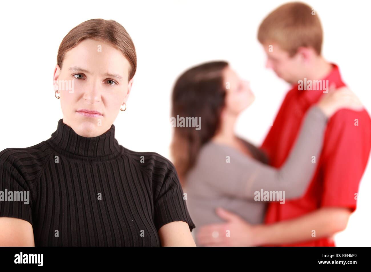 Portrait of jealous girl with lovers in background, studio shot Stock ...