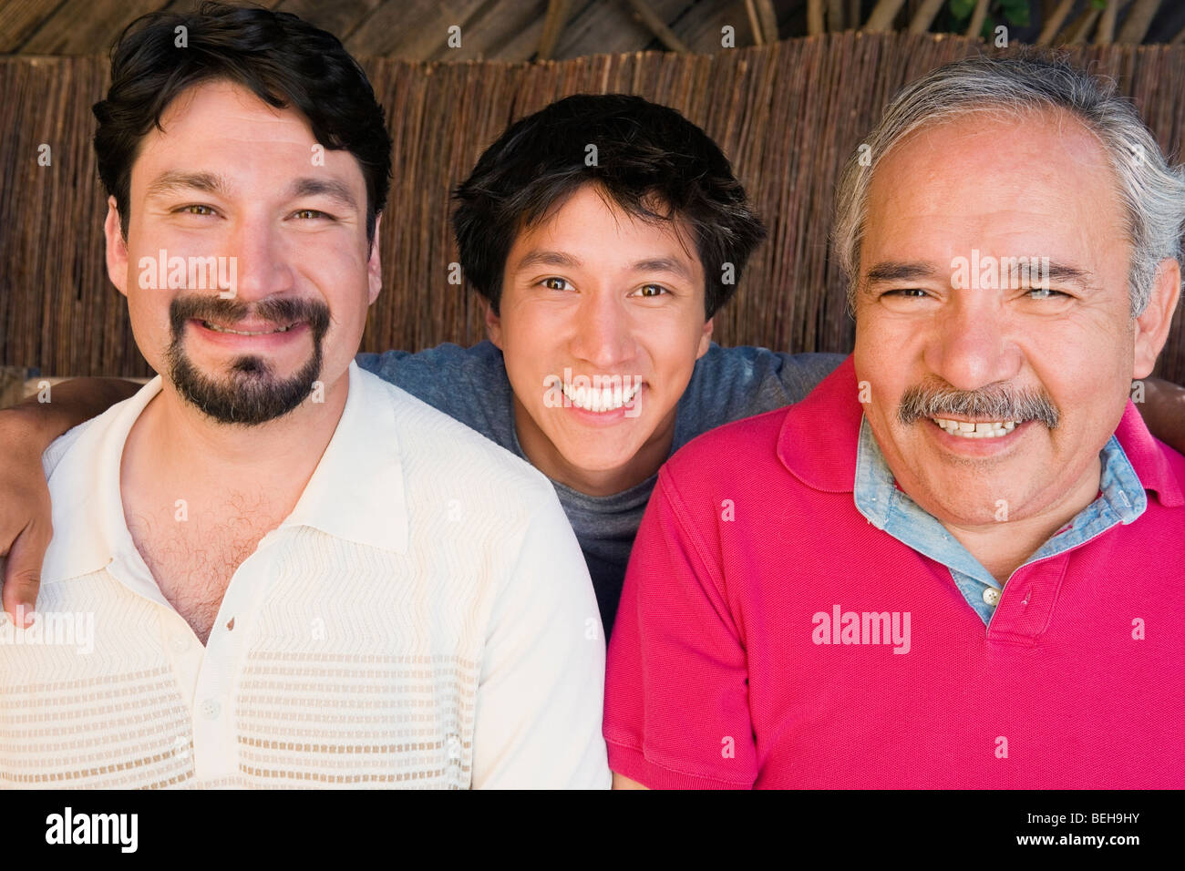 Portrait of a young man smiling with his father and grandfather Stock ...