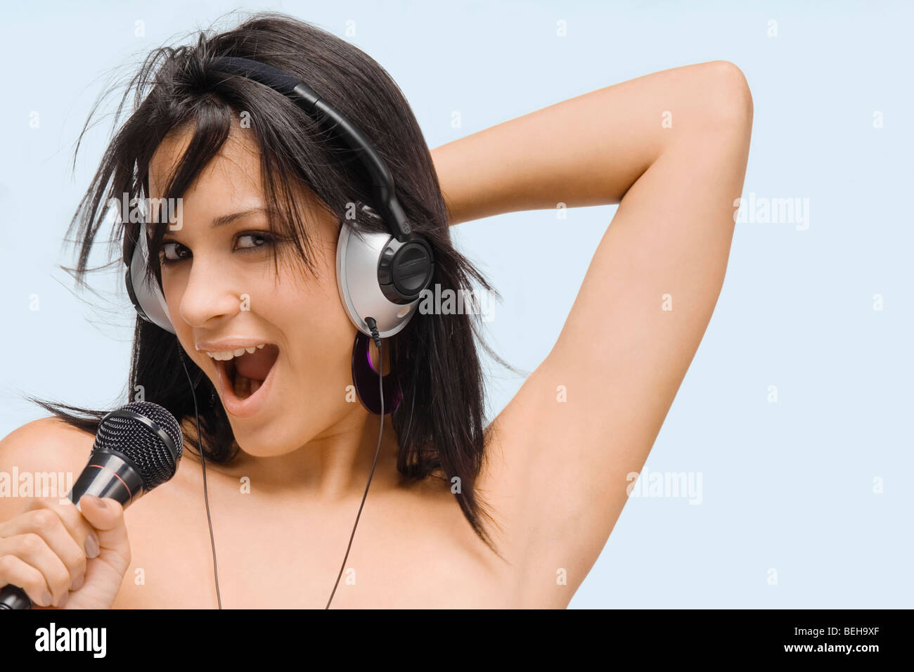 Portrait of a young woman singing into a microphone Stock Photo - Alamy