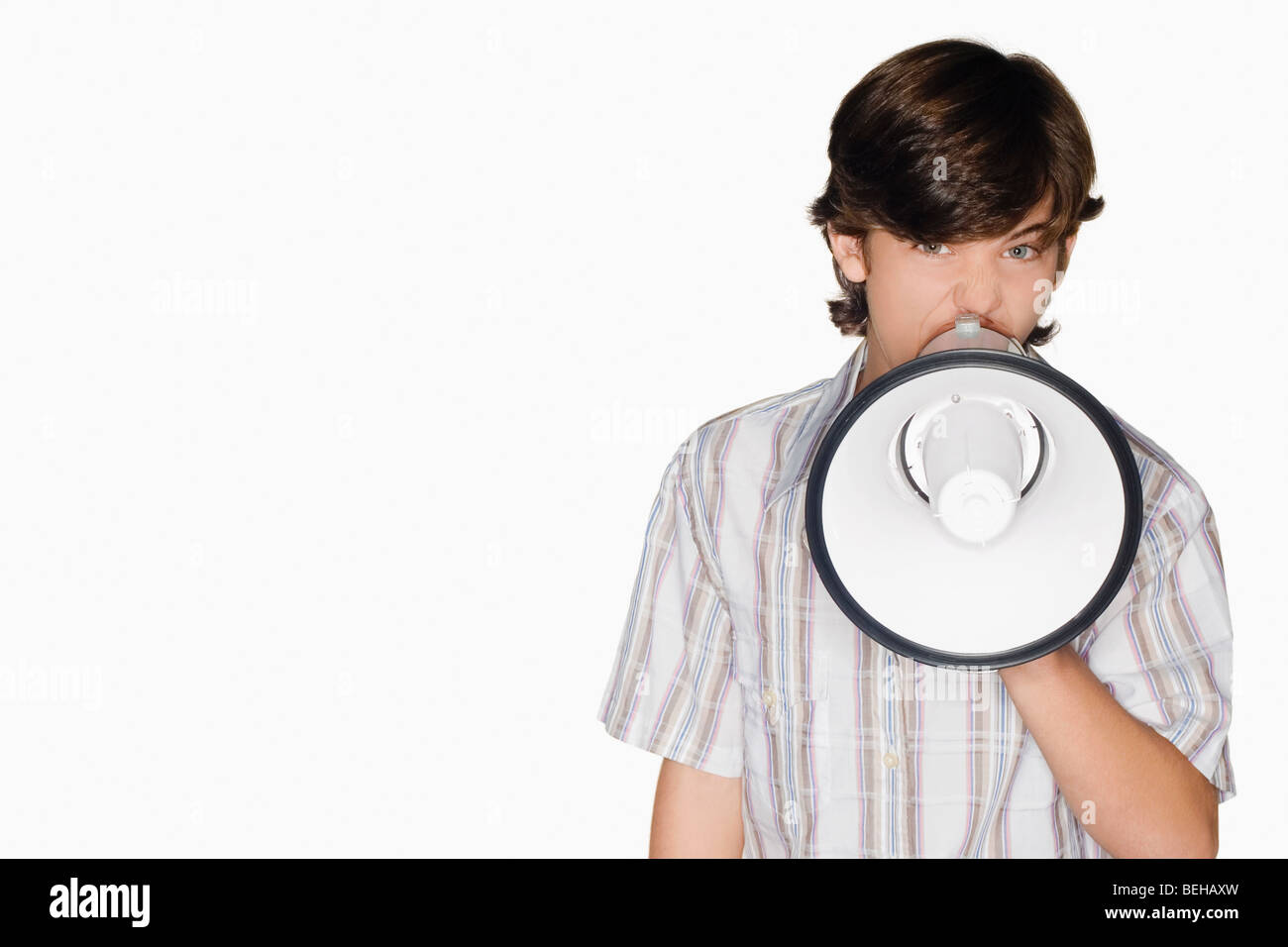 Portrait of a teenage boy blowing a bullhorn Stock Photo - Alamy