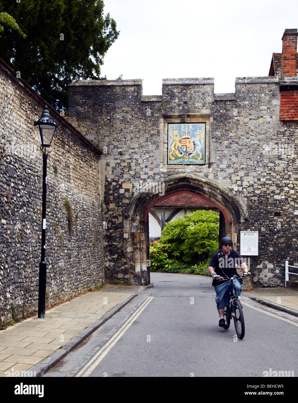 Man on bike stone gate winchester cathedral hi-res stock photography ...