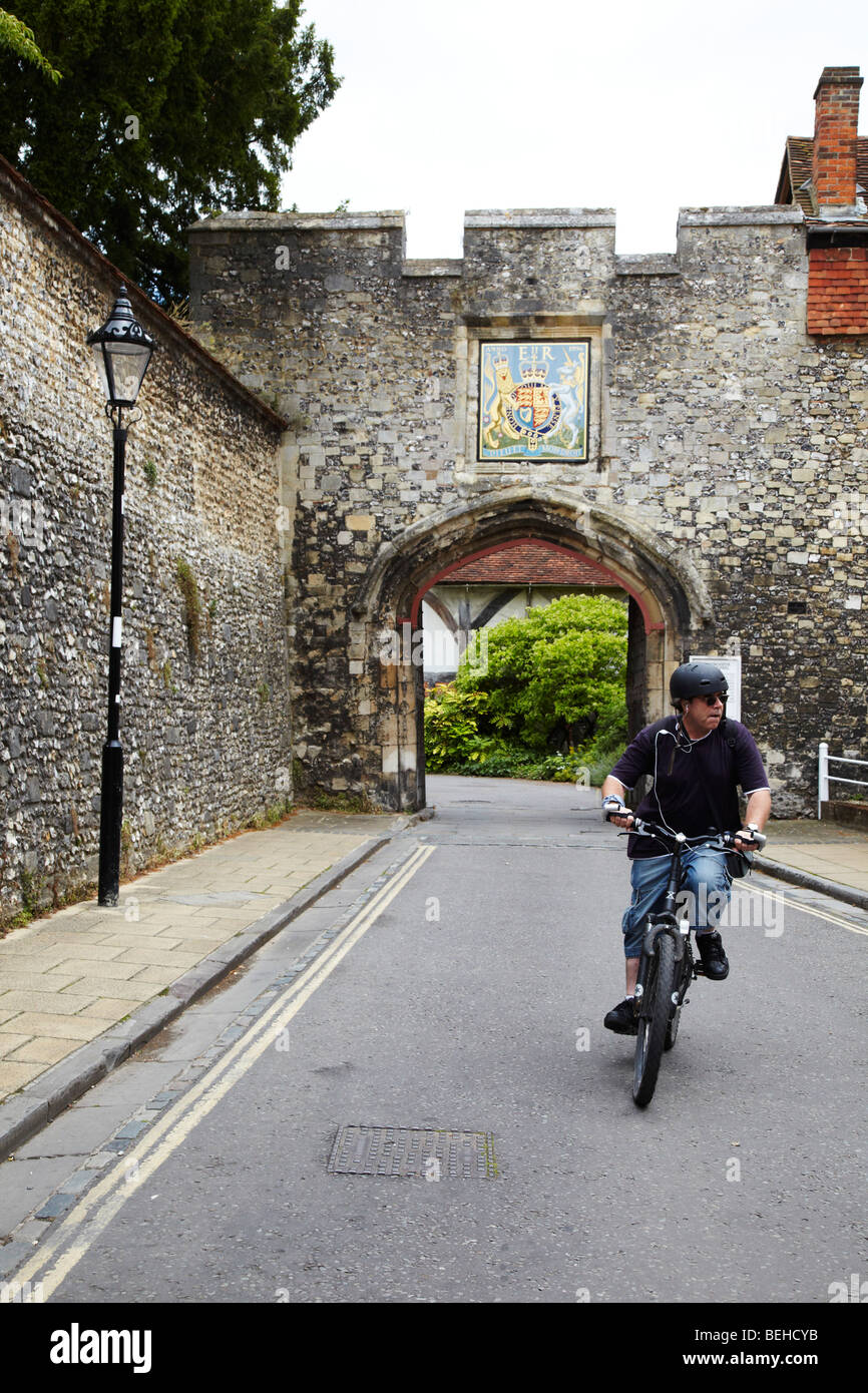 man on bike outside gate, Winchester Cathedral Stock Photo - Alamy