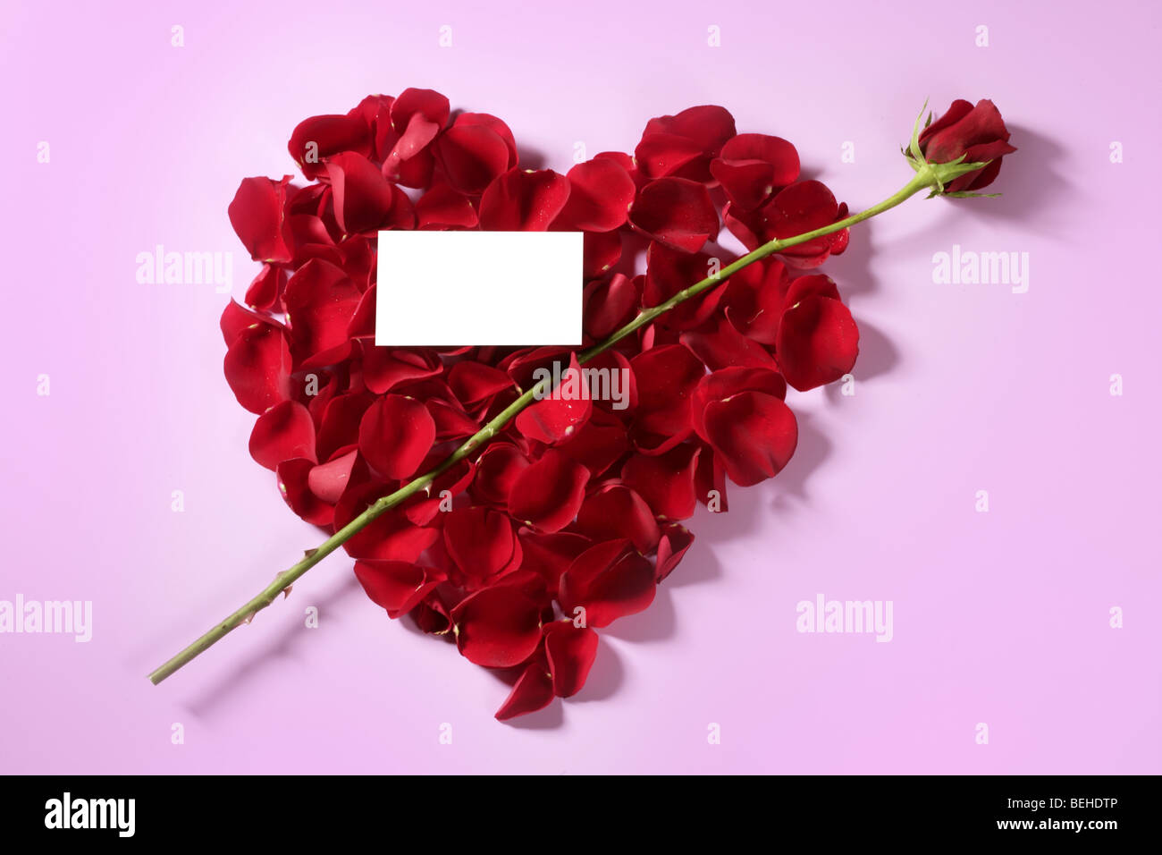 Cupid arrow in a red rose petals heart shape, love symbol Stock Photo ...