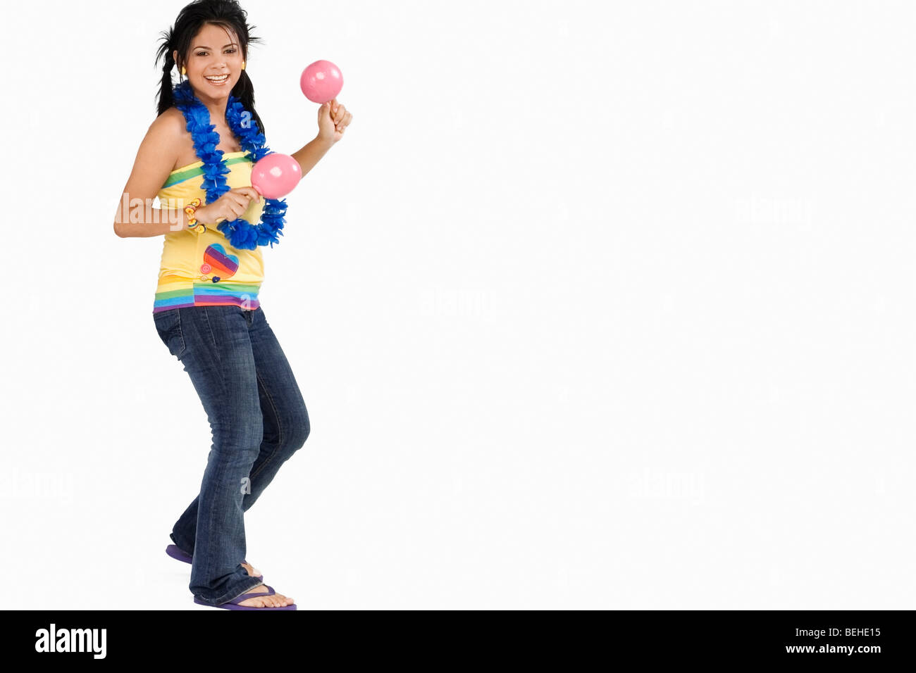 Portrait of a young woman playing maracas and smiling Stock Photo - Alamy