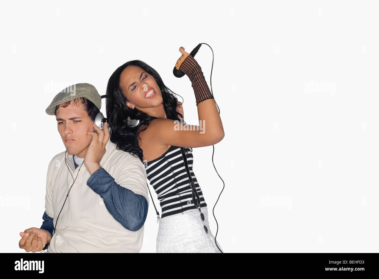 Side profile of a teenage girl singing and a young man listening to ...