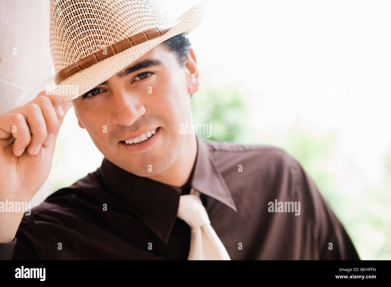 Portrait of a young man tipping hat and smiling Stock Photo - Alamy