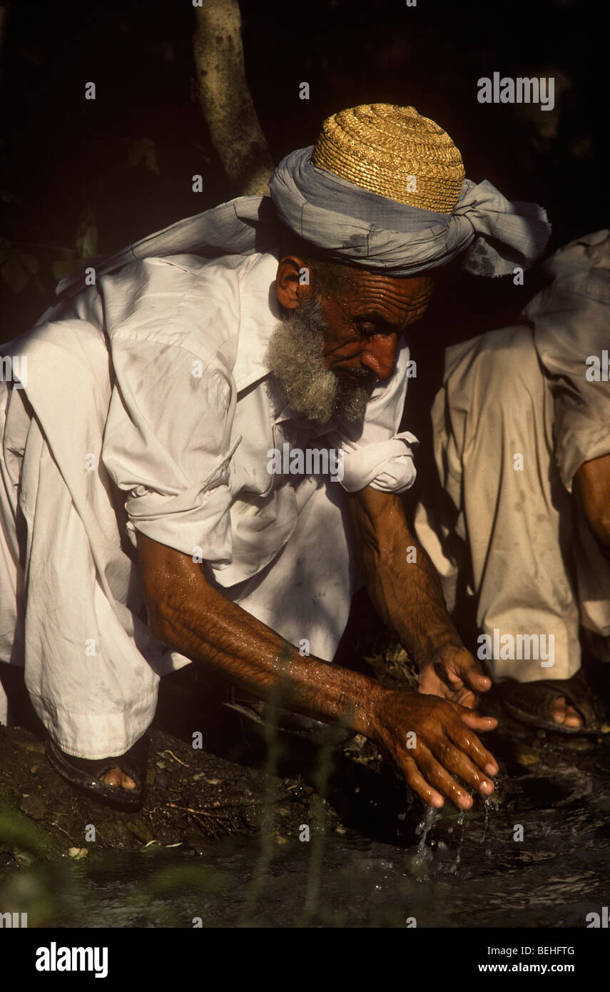 Pathan man washing before prayers at open-air mosque, Kado, Northwest ...
