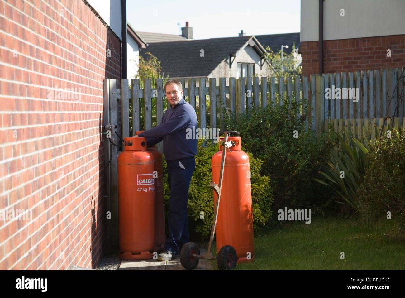 North Wales UK Calor Gas employee changing a 47kg cylinder of propane ...