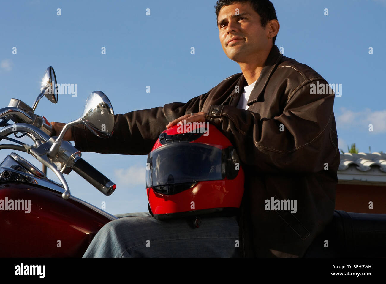 Side profile of a young man sitting on a motorcycle Stock Photo - Alamy