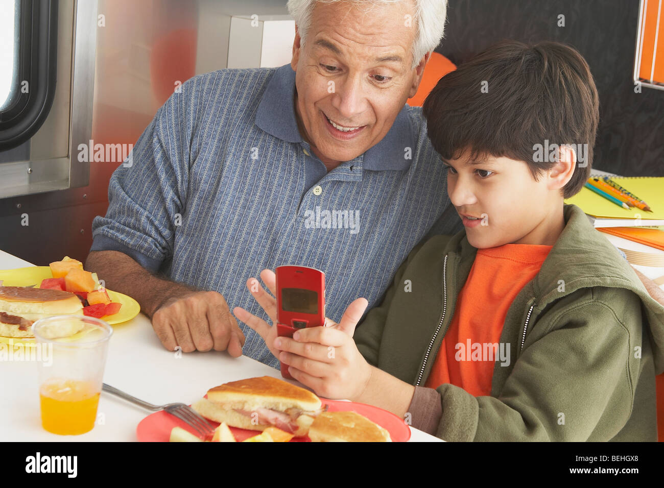 Boy teaching his grandfather how to use a mobile phone Stock Photo - Alamy