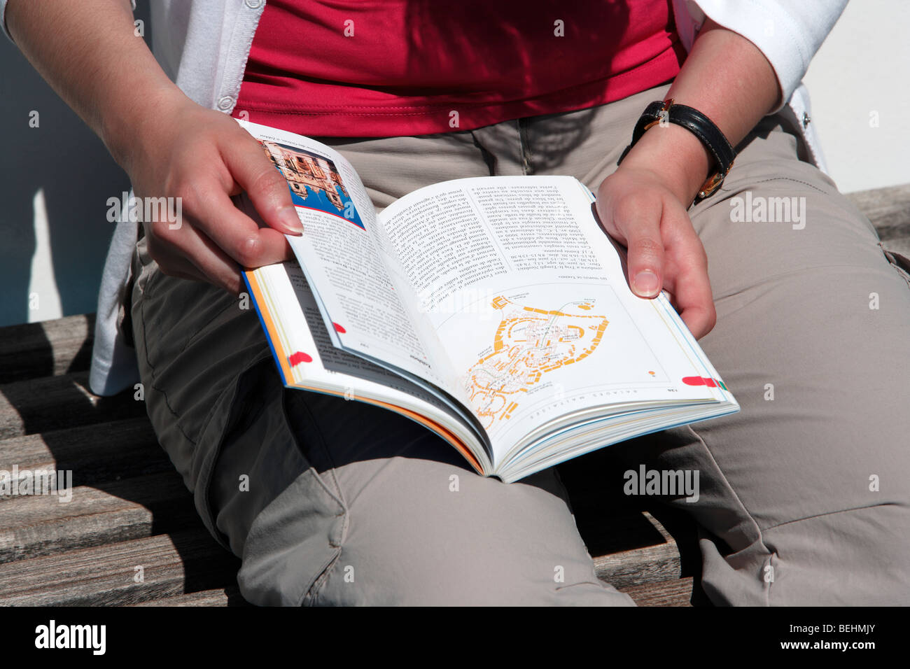 Tourist reading guide book Stock Photo - Alamy