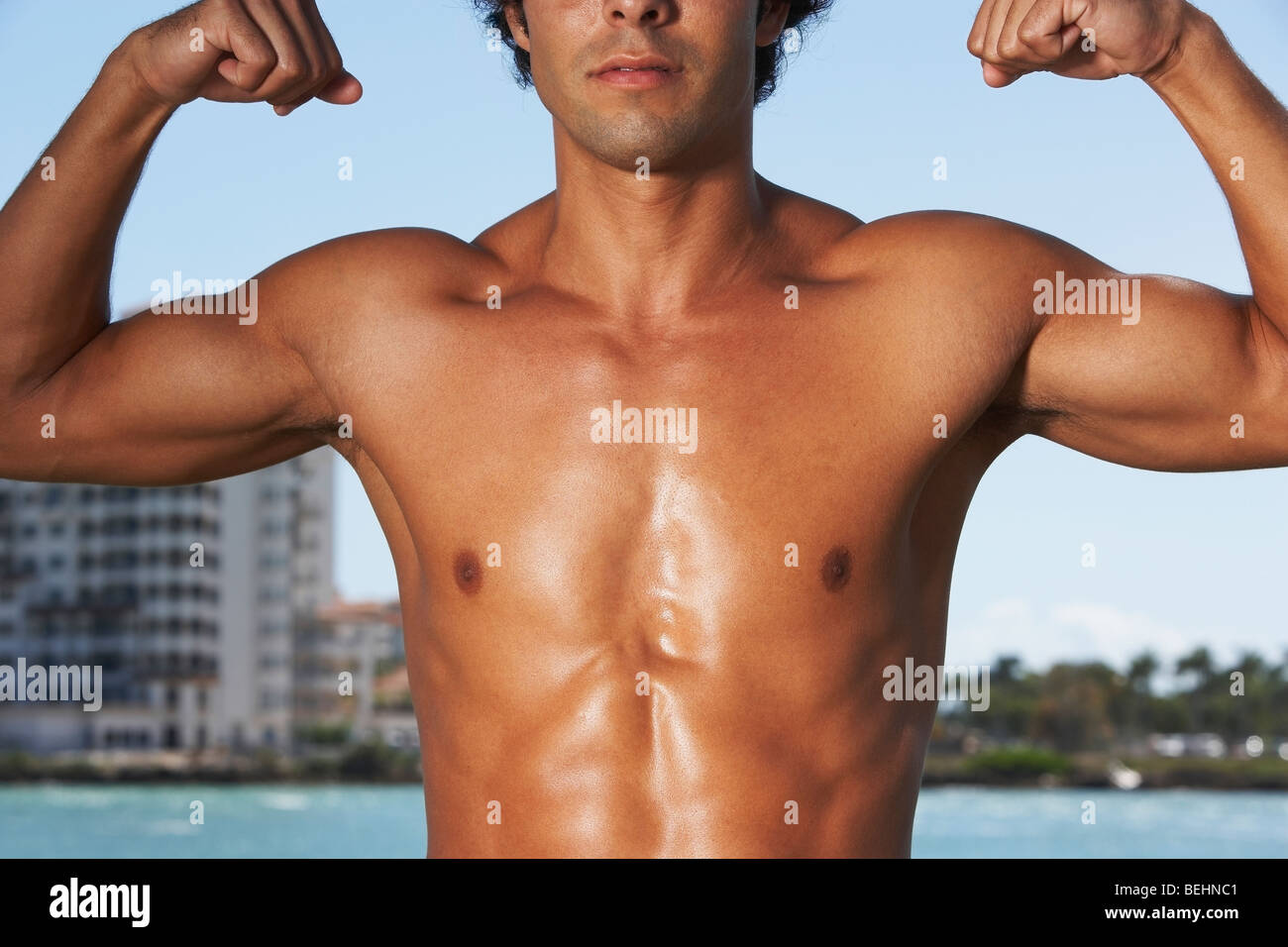 Close-up of a young man flexing his muscles Stock Photo - Alamy