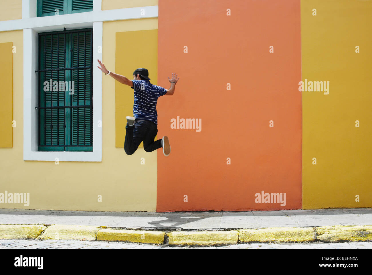 Rear view of a man jumping at the roadside Stock Photo - Alamy