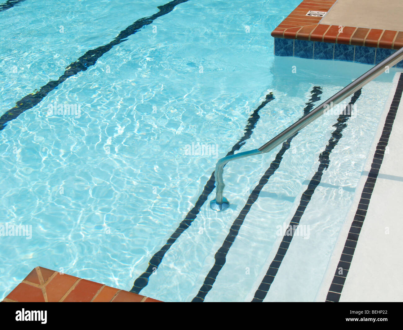 Steps leading down into a refreshing swimming pool in the summertime ...