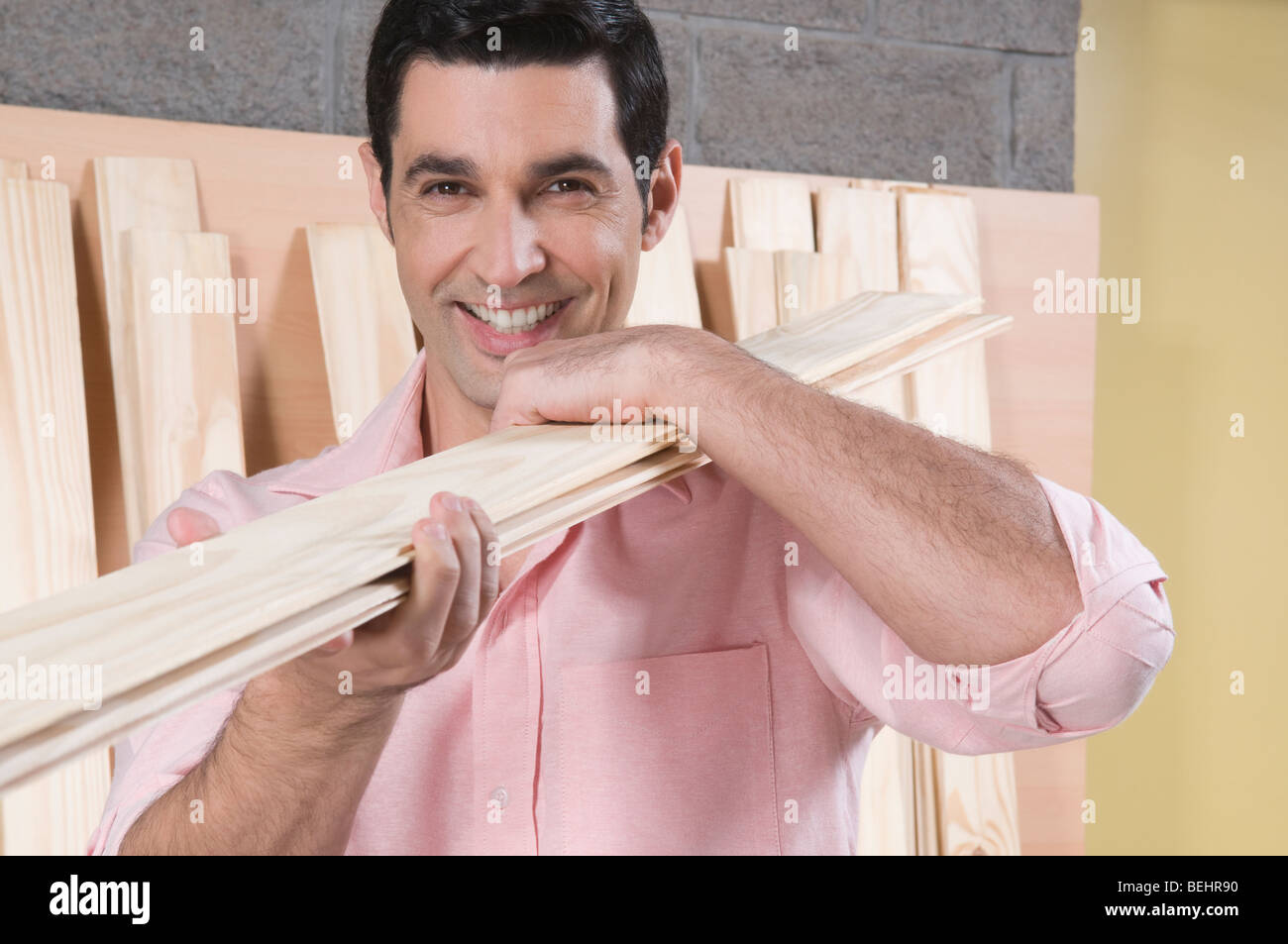 Close-up of a man carrying wooden planks on his shoulder Stock Photo ...